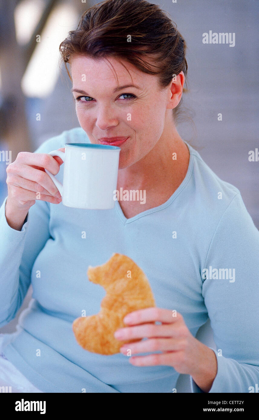 Female wet brunette hair off face wearing pale blue top drinking from ...