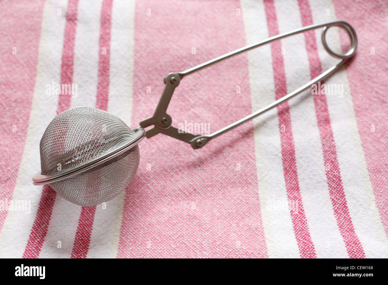 A tea infuser on a textile background Stock Photo - Alamy