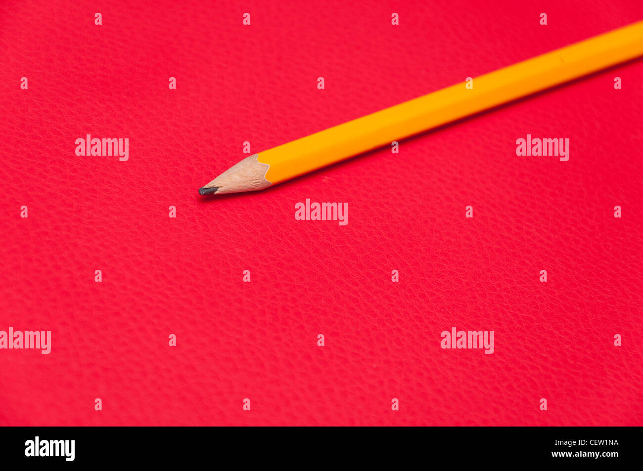 Yellow pencil on red background Stock Photo - Alamy