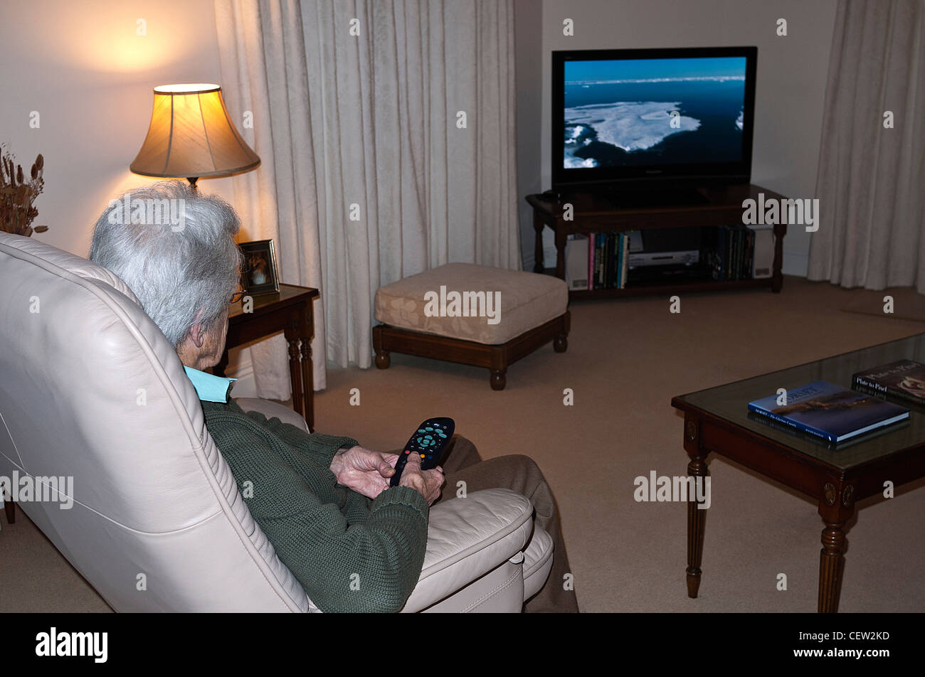 Mature Lady sitting in a lounge watching television Stock Photo - Alamy