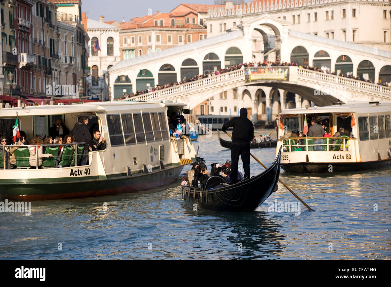 Gondola weaving between two boat buses in venice Stock Photo - Alamy