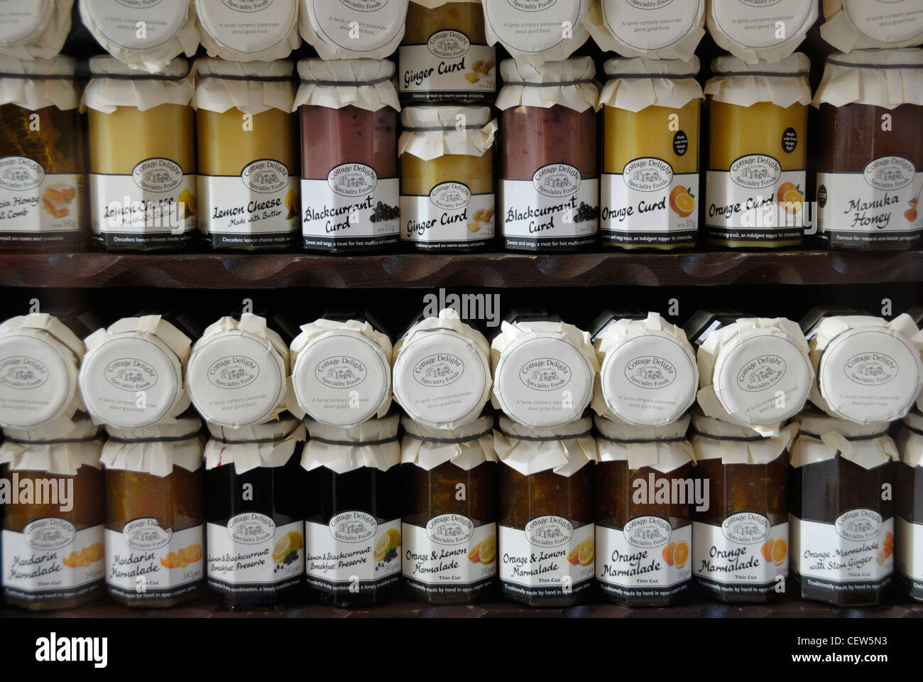 Jars of traditional curd and marmalade on display in a shop window ...