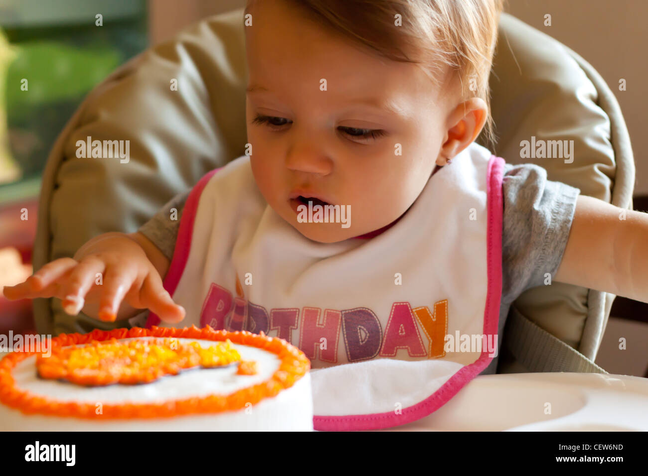 Baby starting to dig into first birthday cake Stock Photo - Alamy