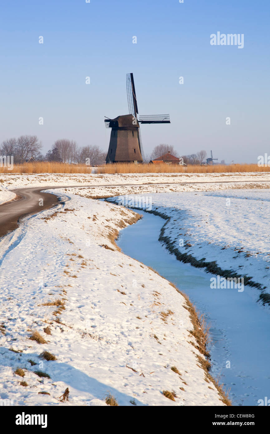Windmill in winter time with snow, ice and blue sky Stock Photo - Alamy