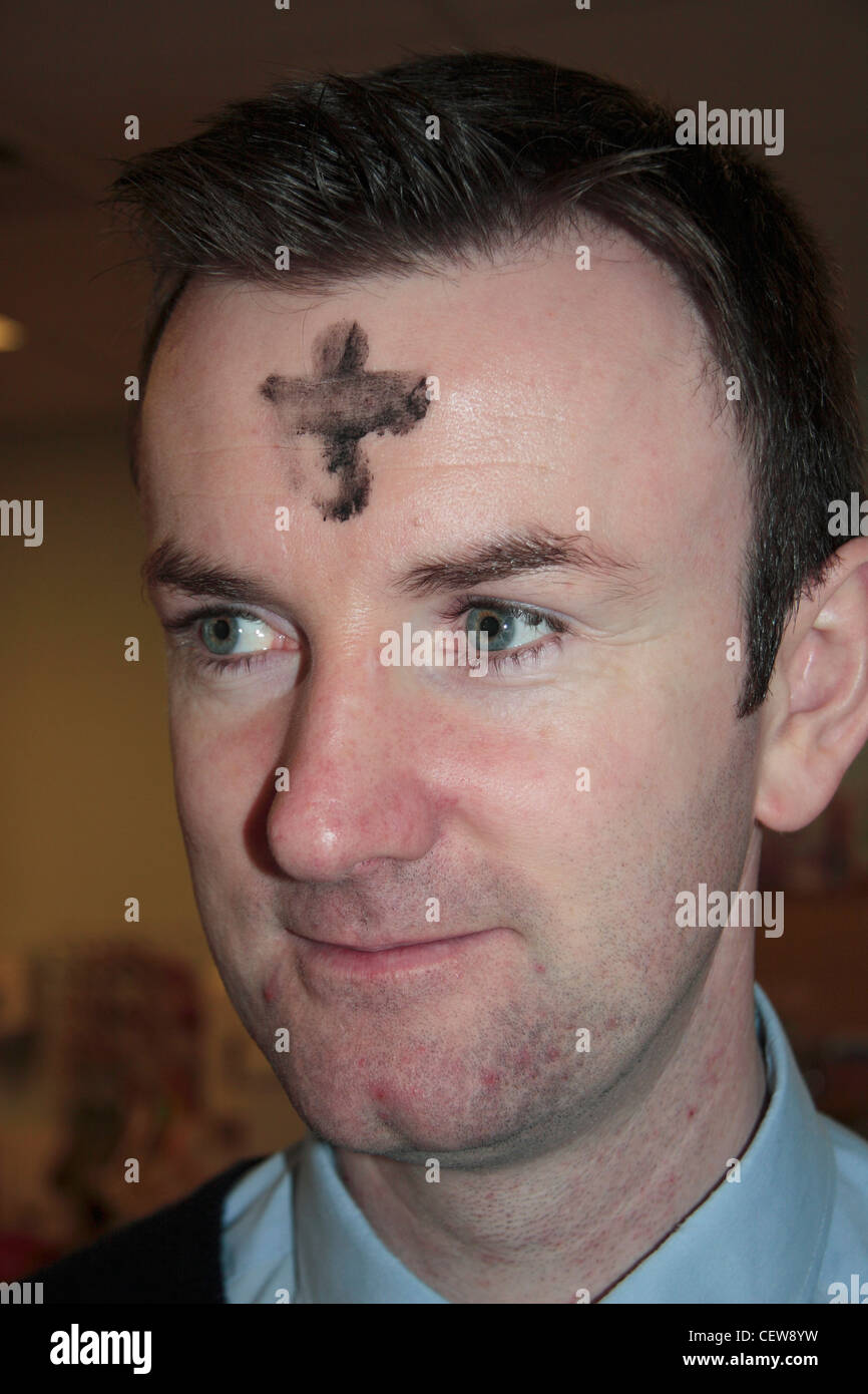 A close up of a cross of ashes on the forehead of a Roman Catholic man ...