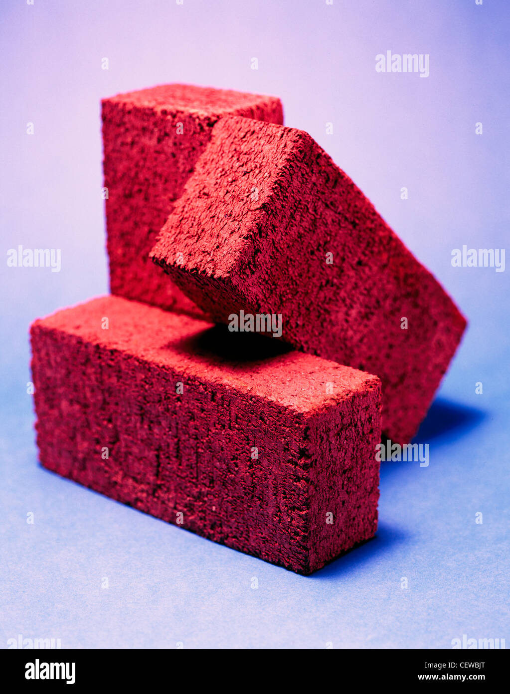 Three red building bricks in a loose pile on a blue background Stock ...
