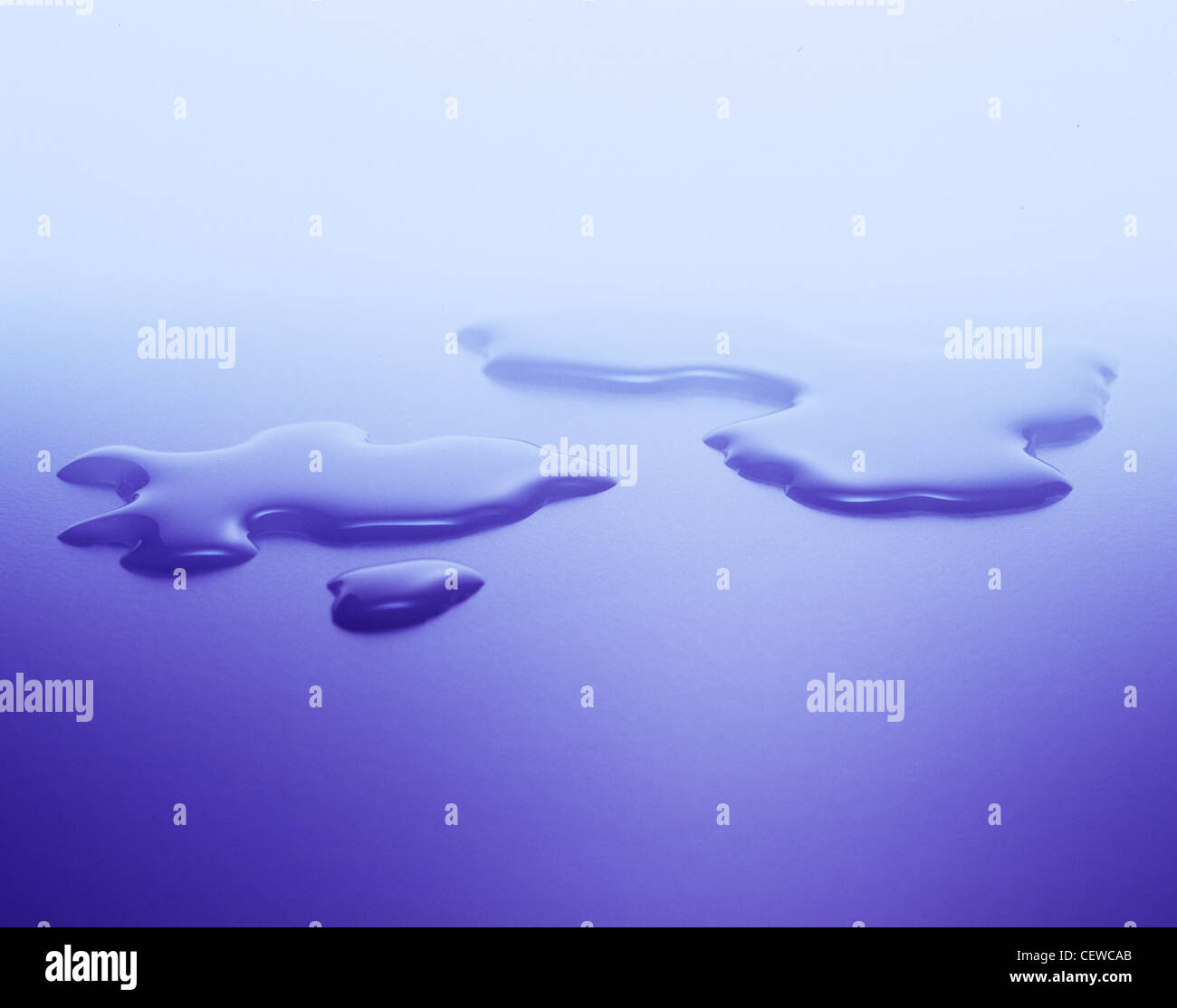 Puddles of water on a blue reflective surface Stock Photo - Alamy