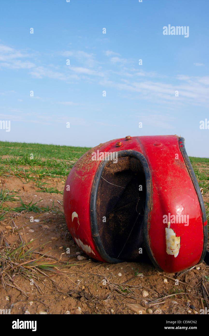 Broken red helmet lying on a field Stock Photo - Alamy