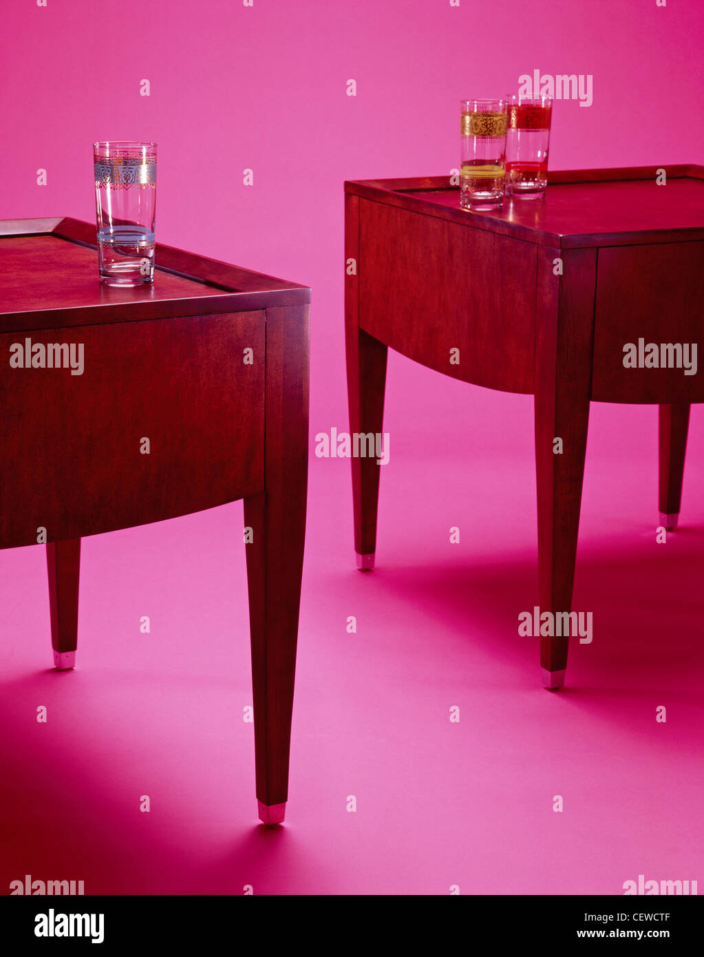 Two household furniture tables together on a bright pink background ...