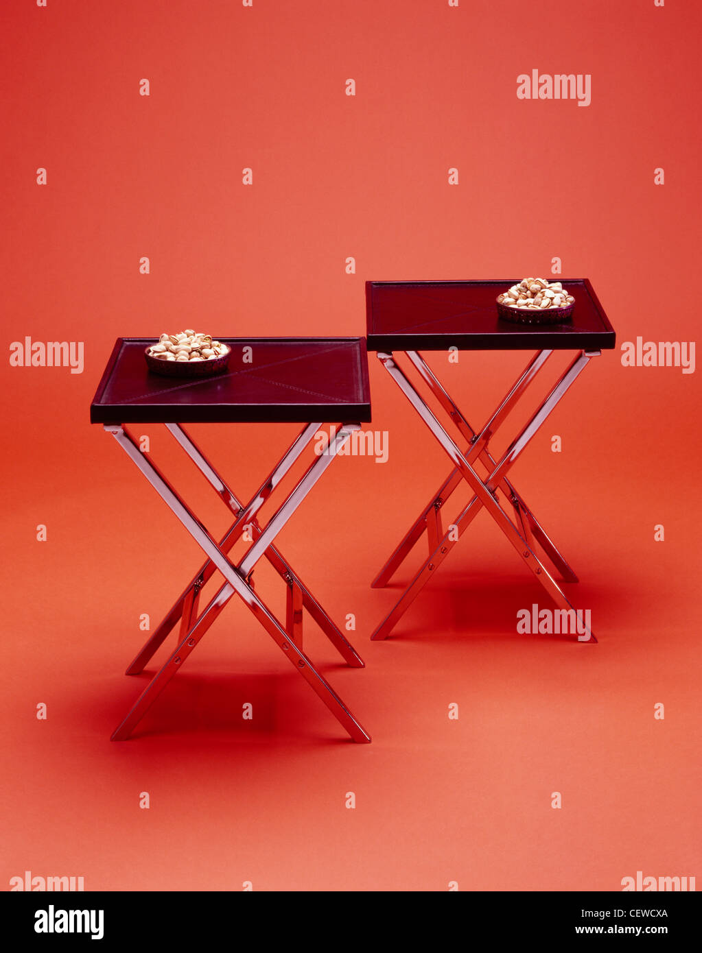 Two household furniture tables together on a bright orange background ...
