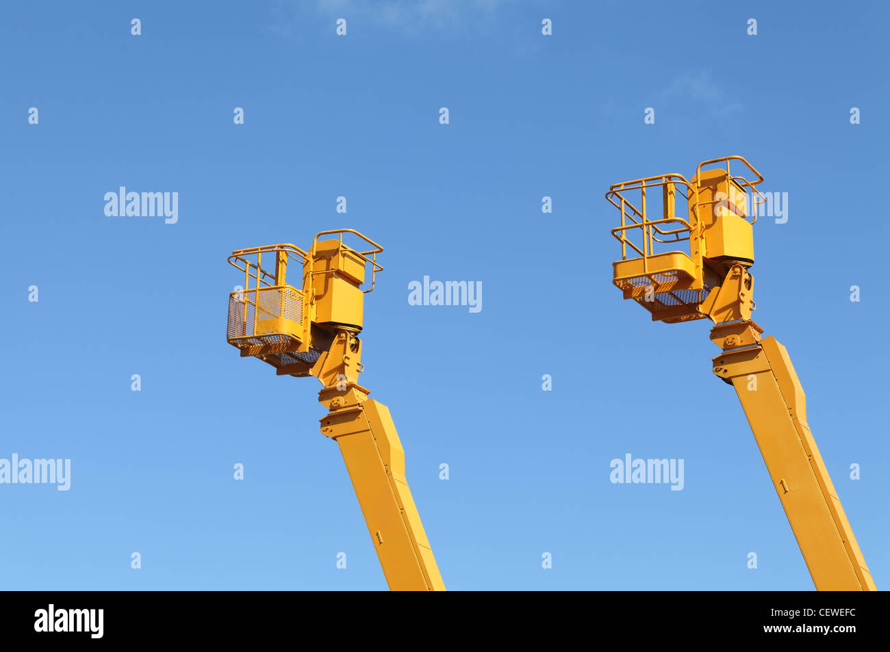 Yellow cherry picker against a blue sky Stock Photo - Alamy