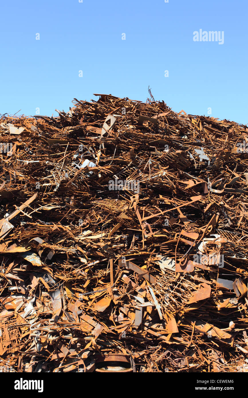 Stack of scrap metal against blue sky Stock Photo - Alamy