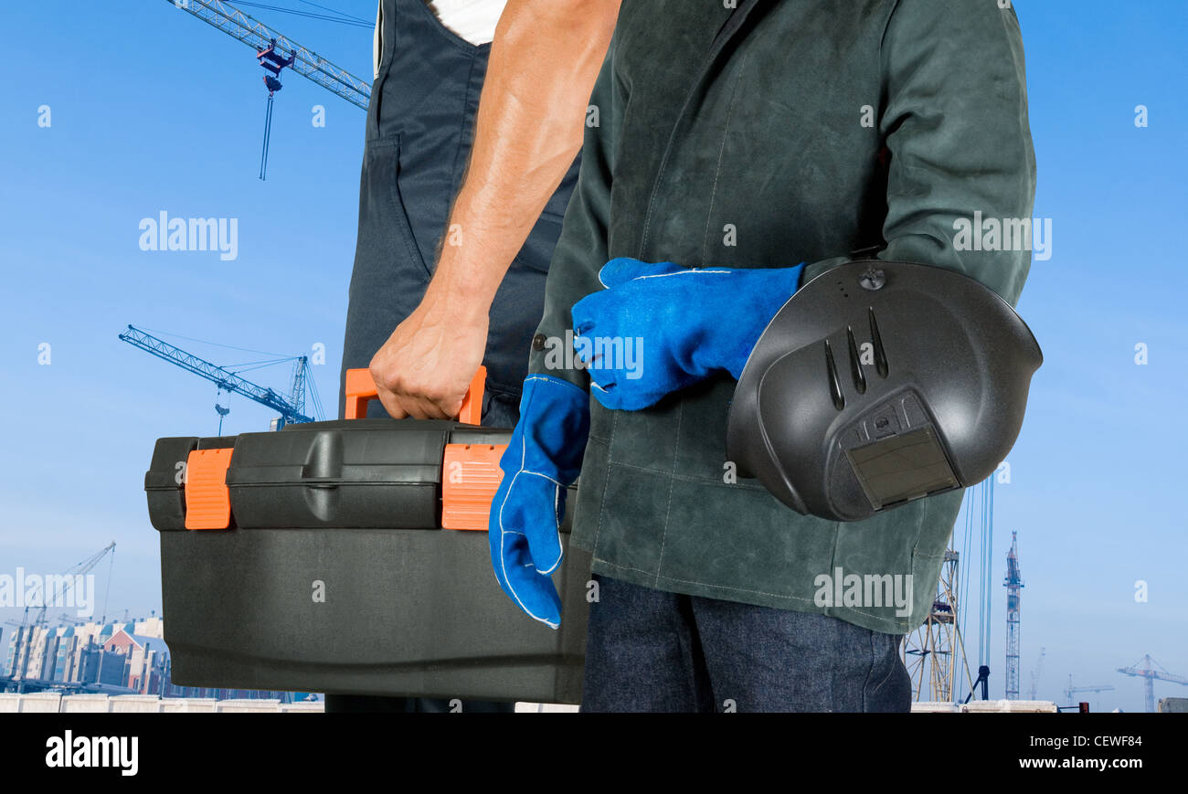 male welder closeup with welding equipment and worker on building ...