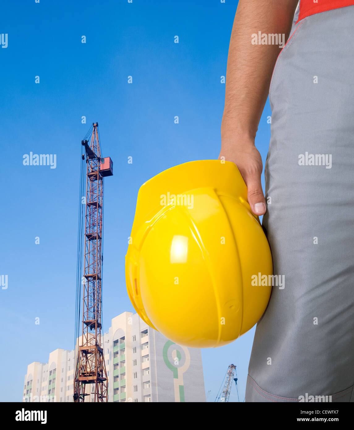 Closeup of builder with yellow helmet on building panorama background ...