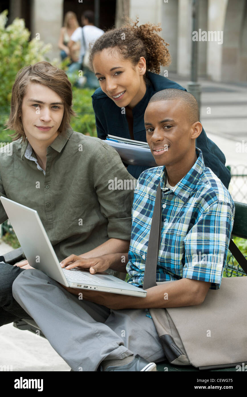 University students studying on campus with laptop computer, portrait ...