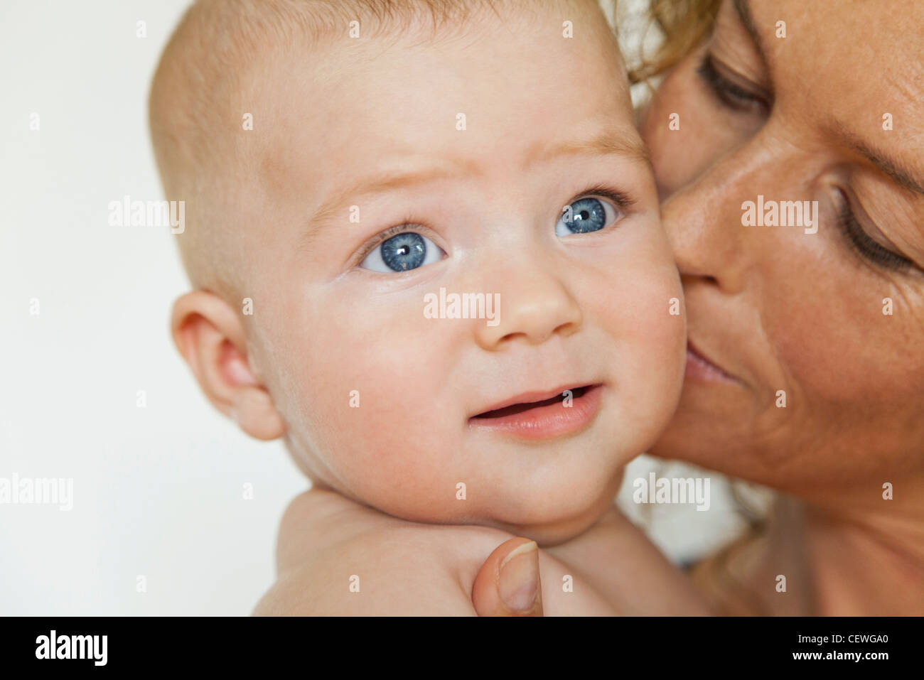 Mother kissing baby's cheek Stock Photo - Alamy