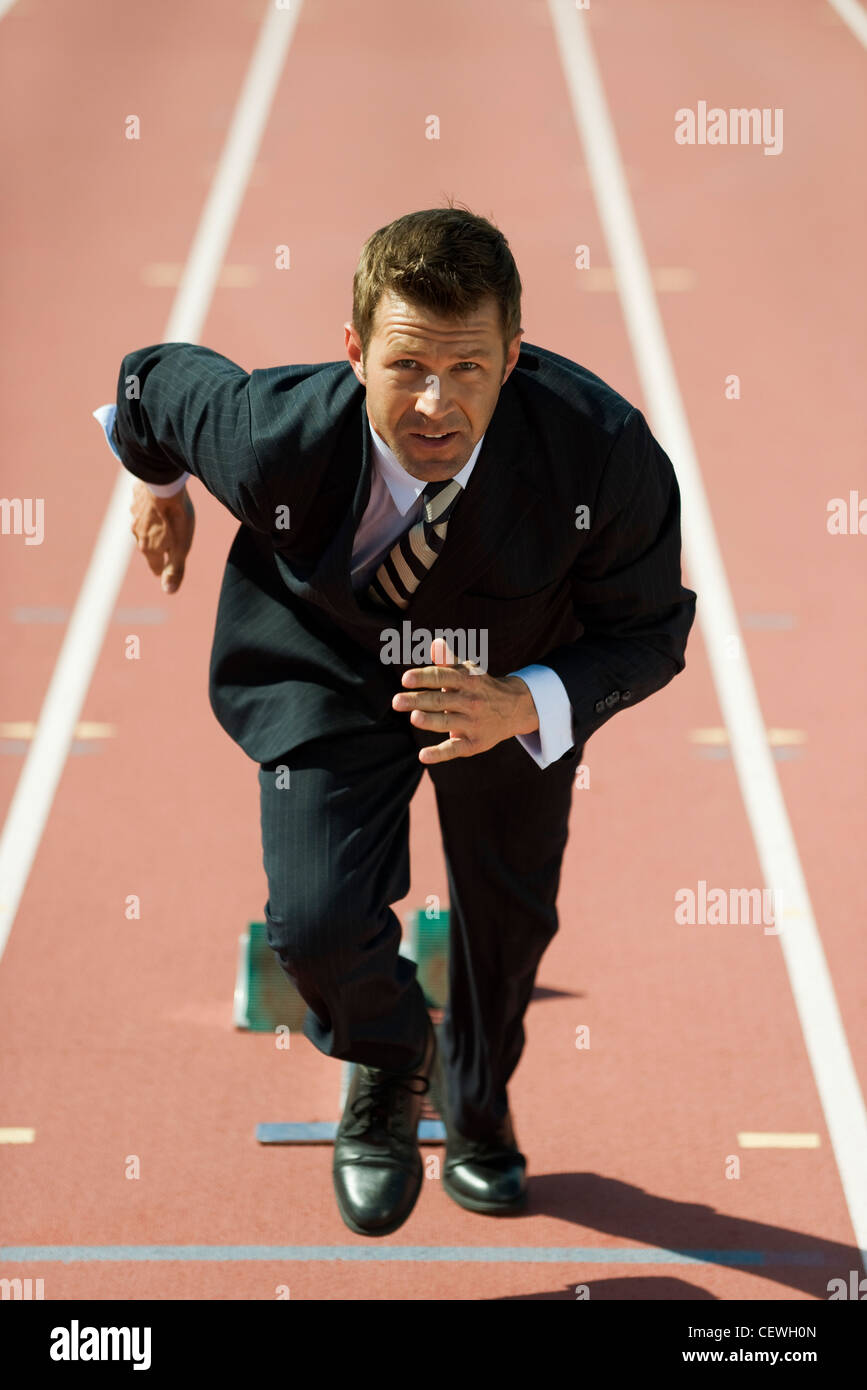 Businessman at starting line on running track Stock Photo - Alamy