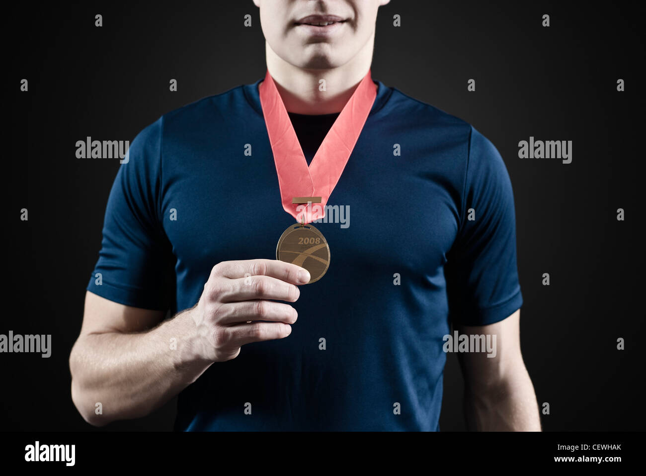 Male athlete holding medal, mid section Stock Photo - Alamy