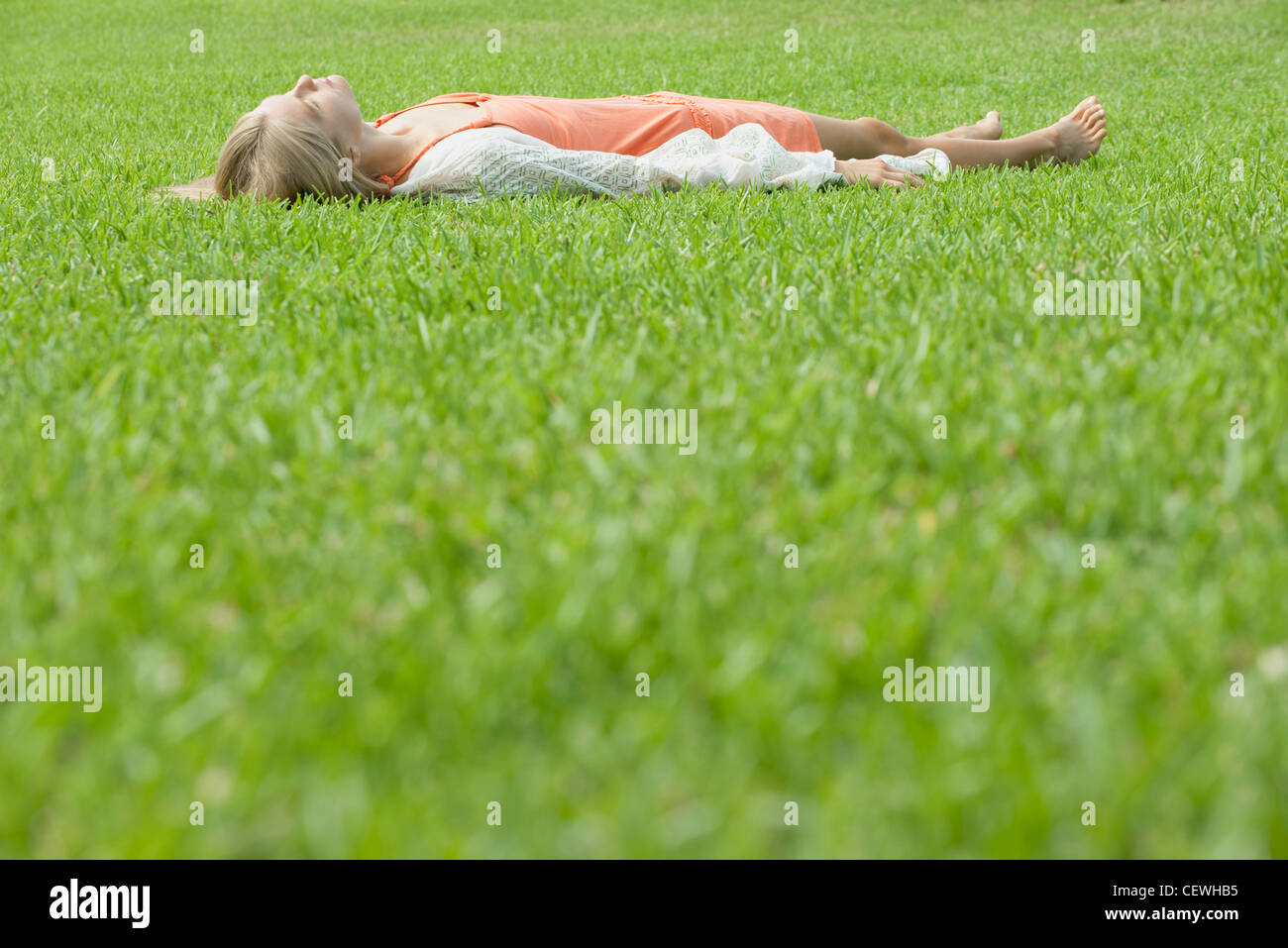 Young woman napping on grass Stock Photo - Alamy