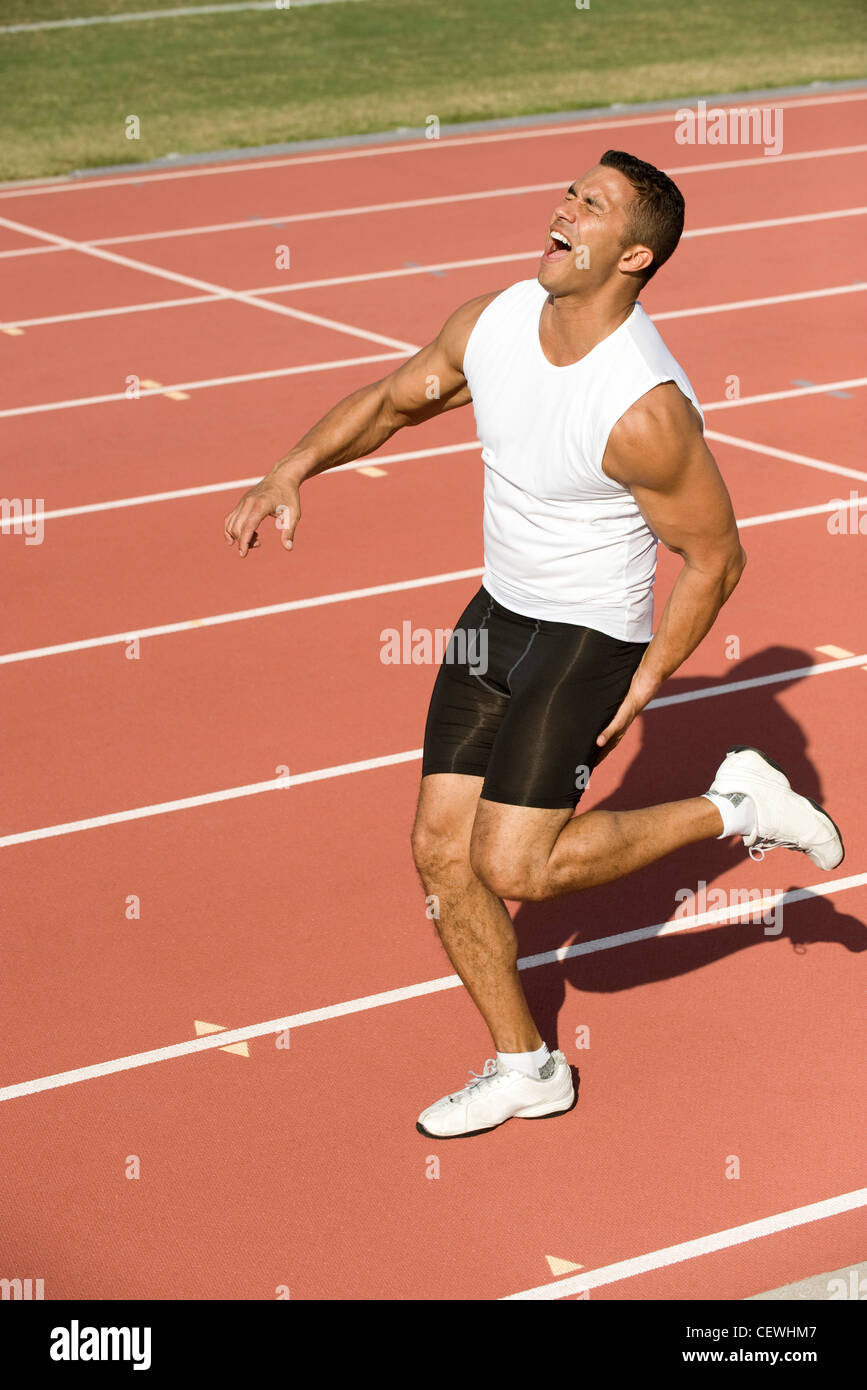 Runner injured while running on track Stock Photo - Alamy