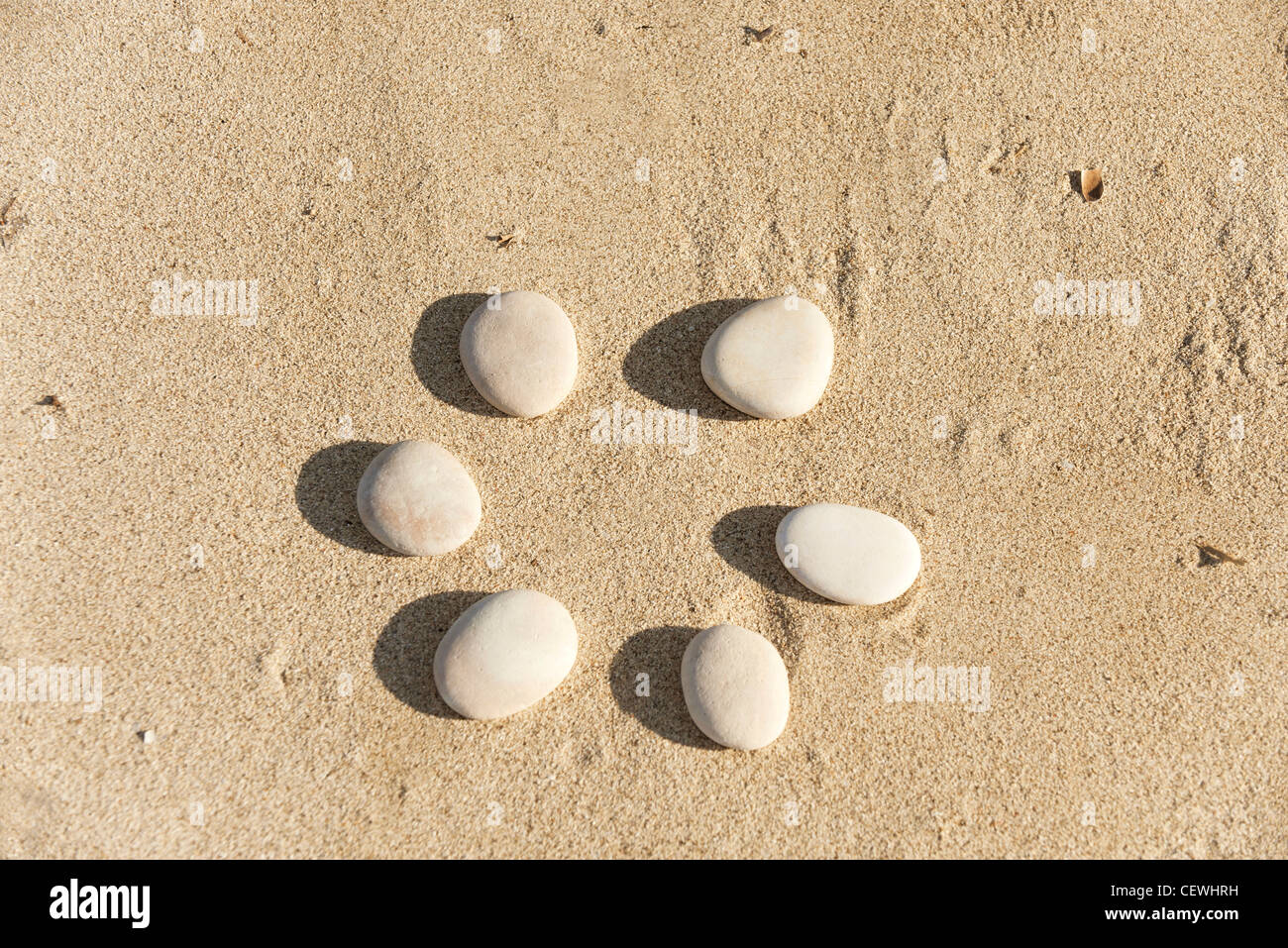 Pebbles arranged in circle on sand Stock Photo - Alamy