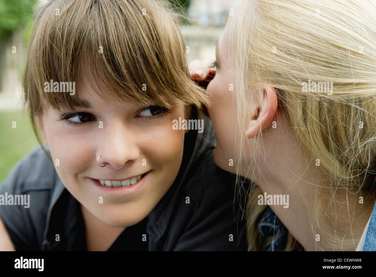 Women whispering in friends ear hi-res stock photography and images - Alamy