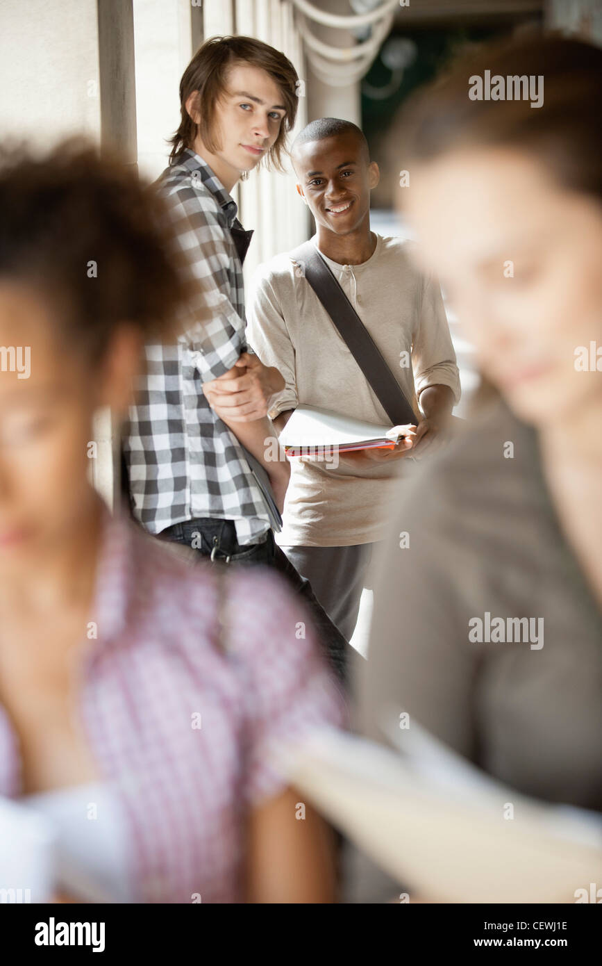 University students discussing homework outdoors, focus on background ...