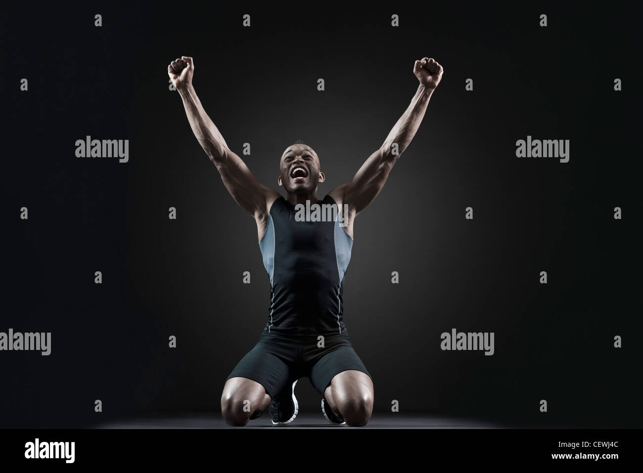 Male athlete shouting with arms raised Stock Photo - Alamy