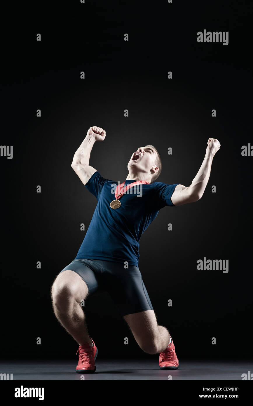 Male athlete shouting with arms raised in victory Stock Photo - Alamy