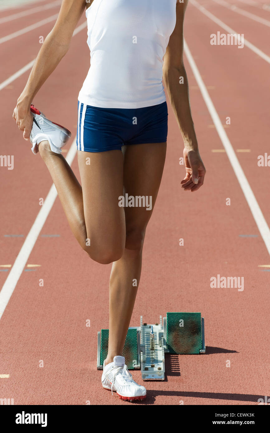 Female runner stretching, cropped Stock Photo - Alamy