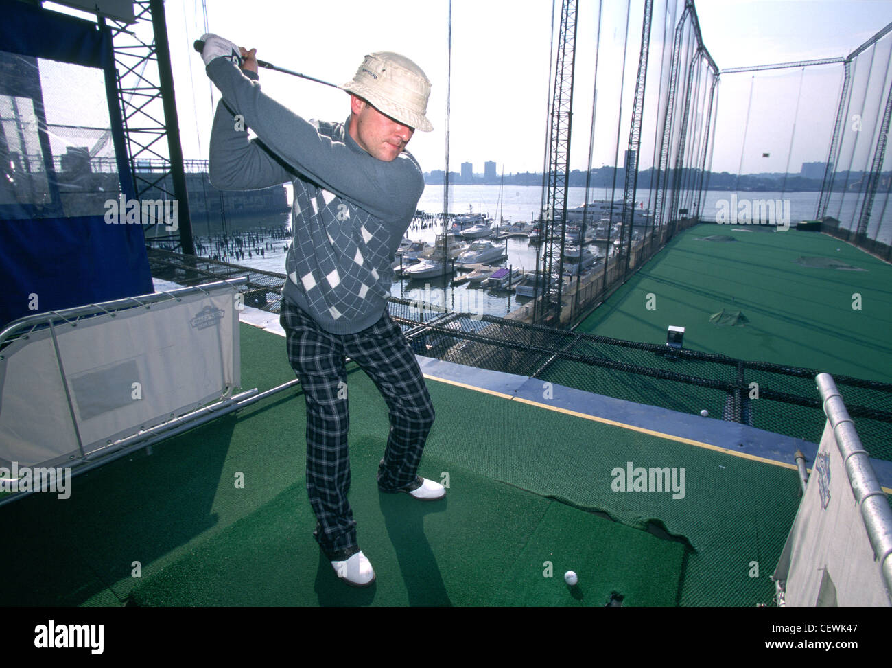 Golfer at driving range with city skyline on bay Stock Photo - Alamy