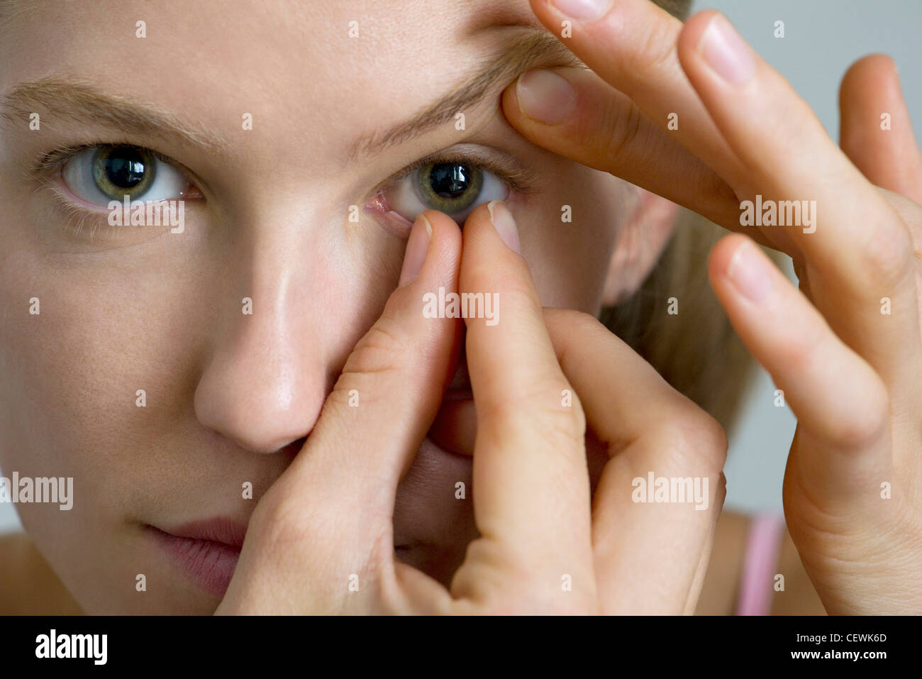 Young woman putting in contact lens Stock Photo - Alamy