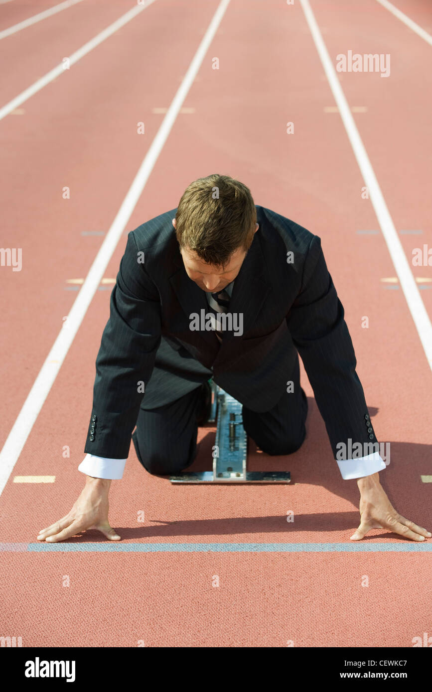 Businessman crouching at starting line on running track Stock Photo - Alamy