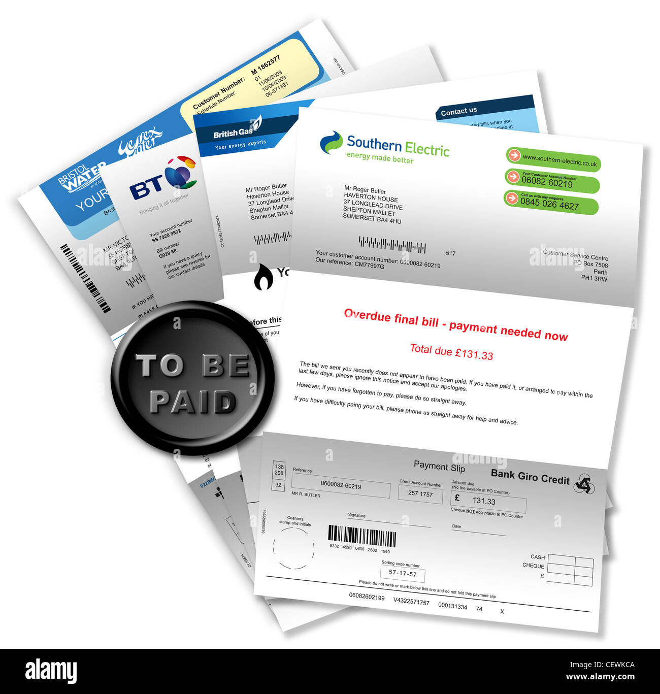 Still life image of household bills and black "To be paid" sign on top ...