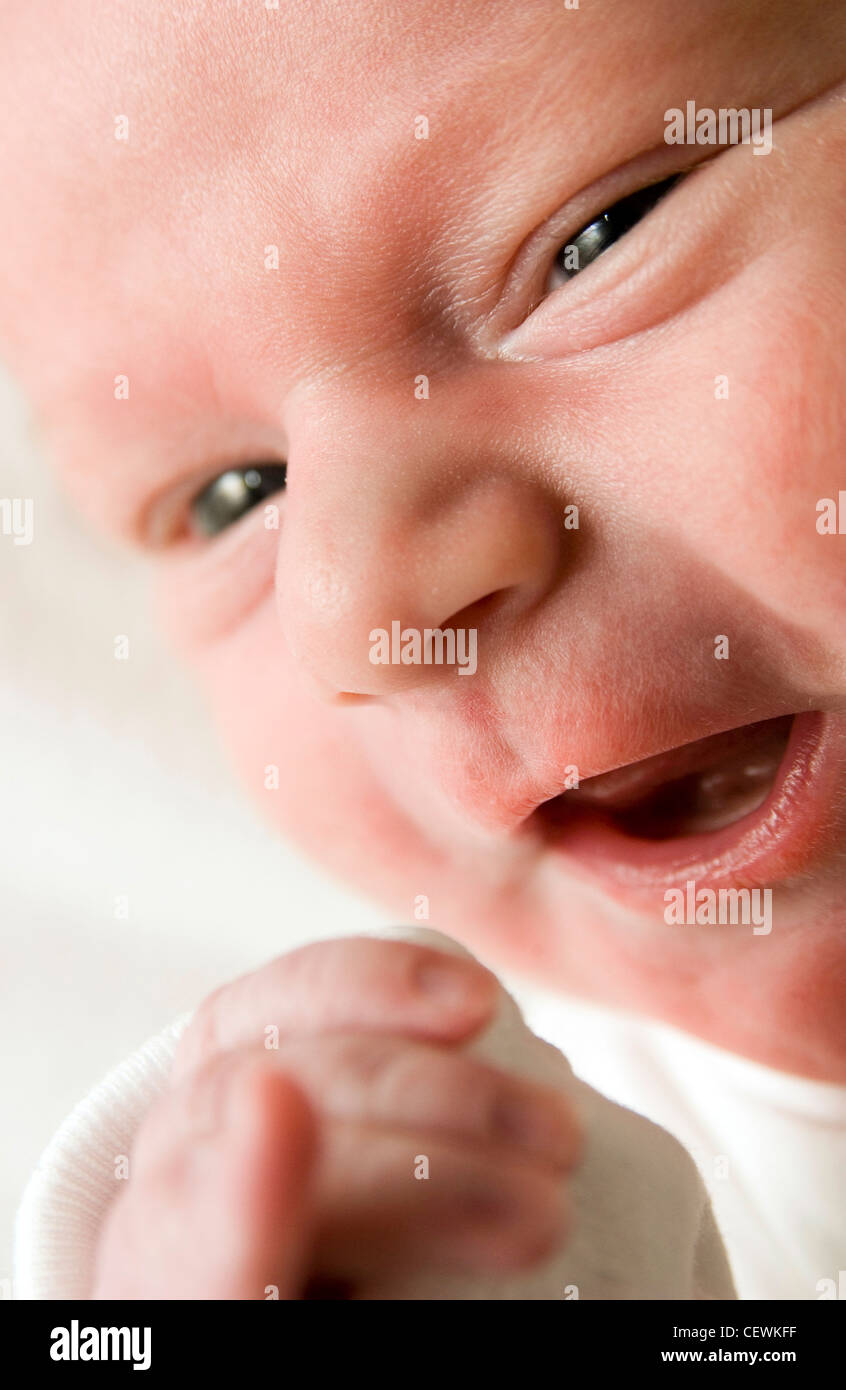Close up of new born baby crying with hand in front of open mouth Stock ...