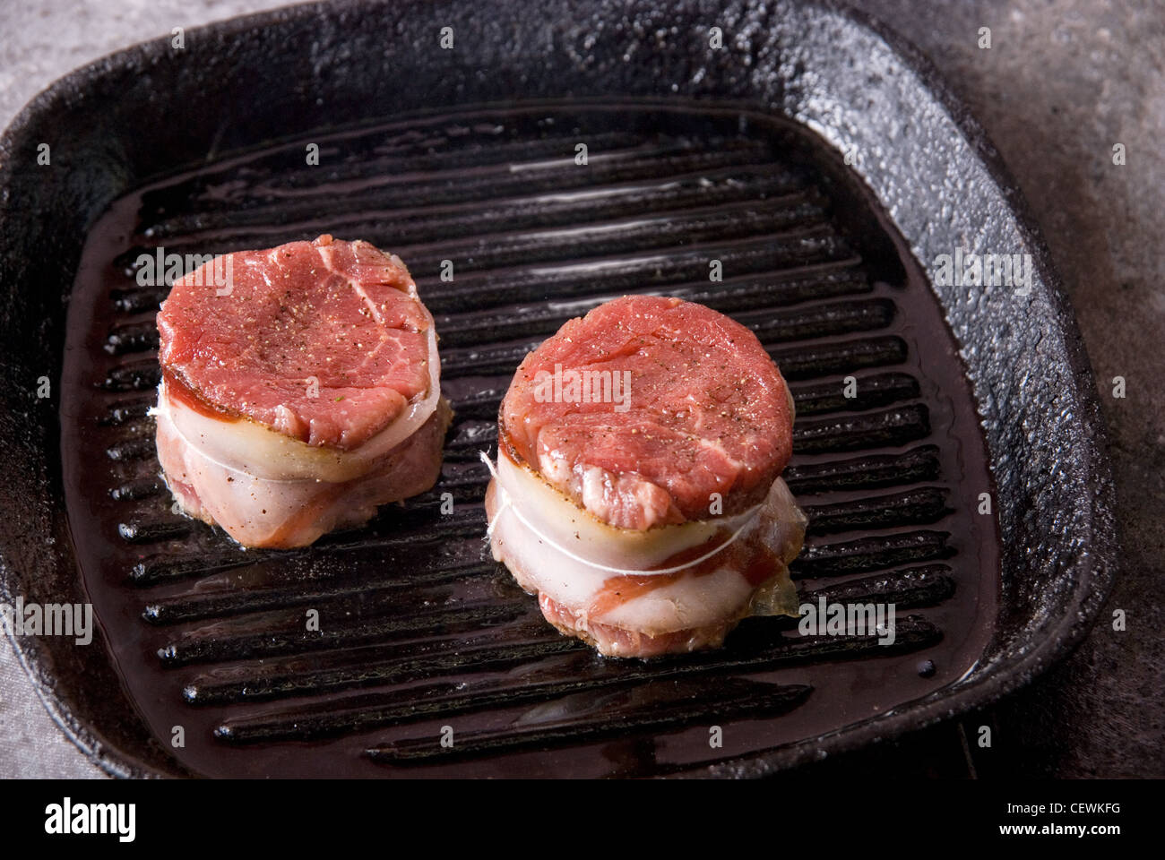 Tasty beef steak grilling in a cast-iron ribbed fry pan Stock Photo - Alamy