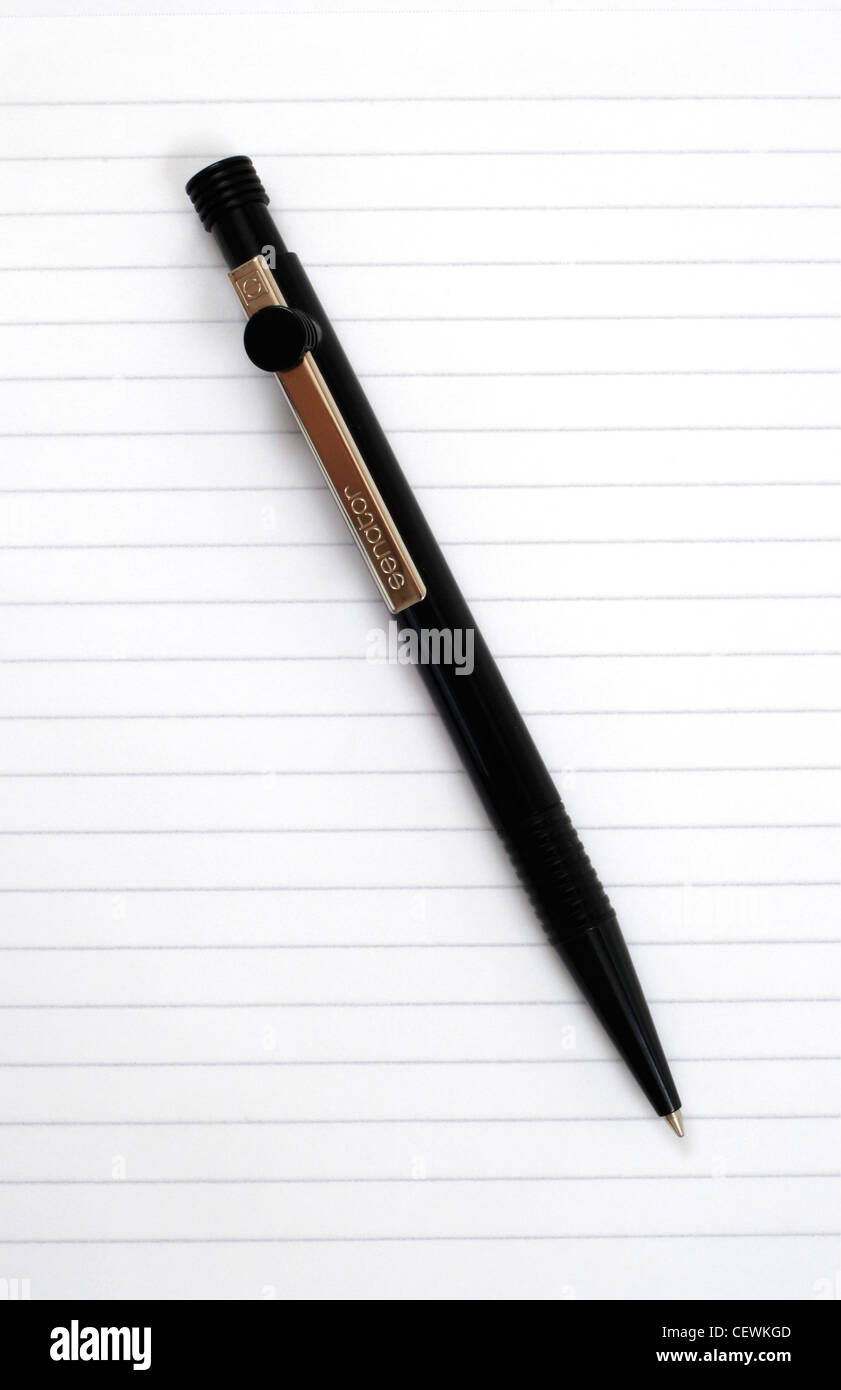 Close up of a spiral bound pad of paper with a black pen ball point pen ...