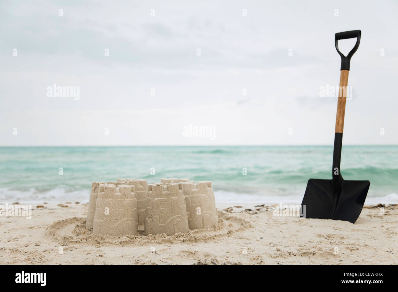 Shovel stuck in sand beside sand castle at the beach Stock Photo - Alamy