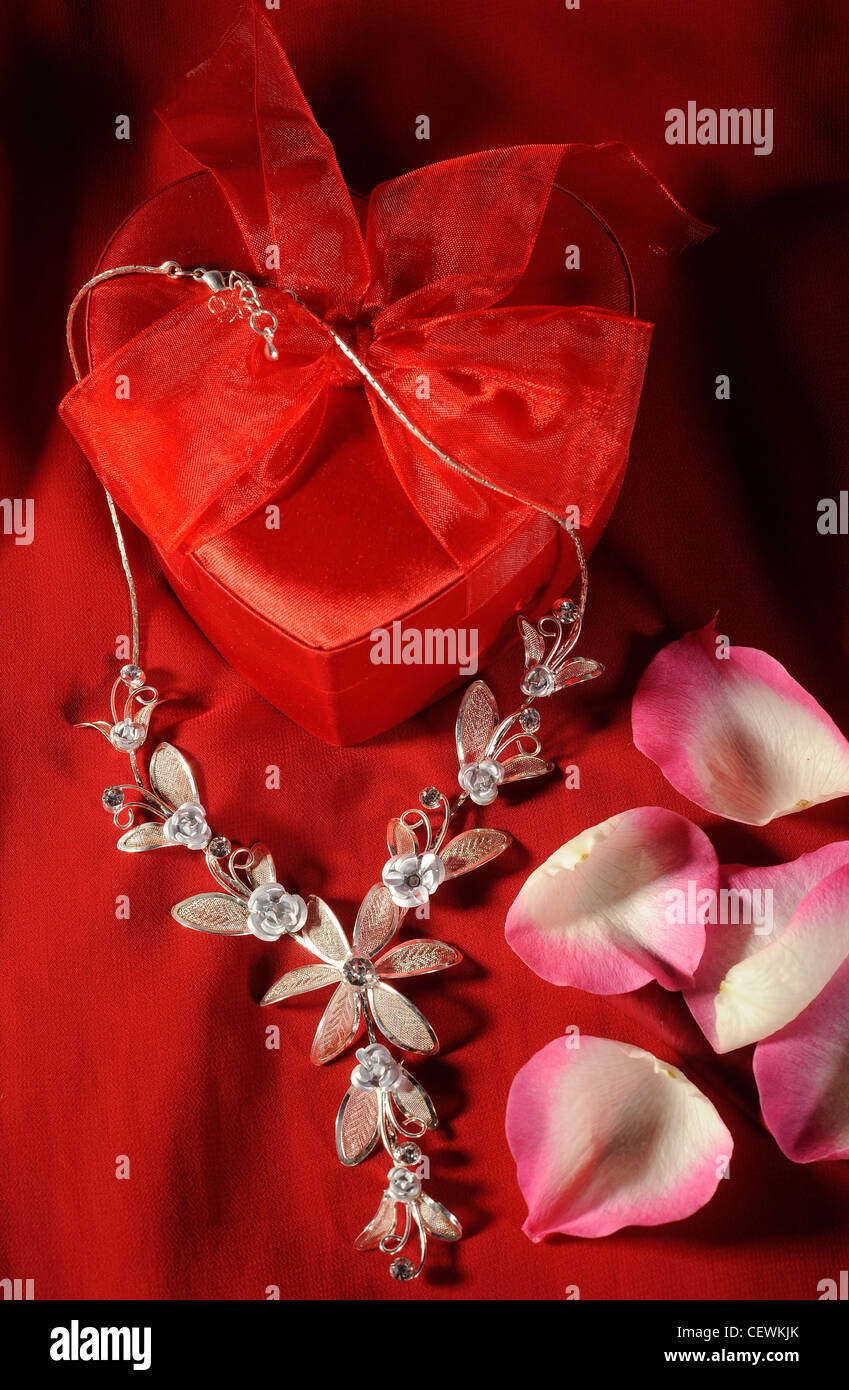 Still life image of red heart shaped gift box with red ribbon, floral ...