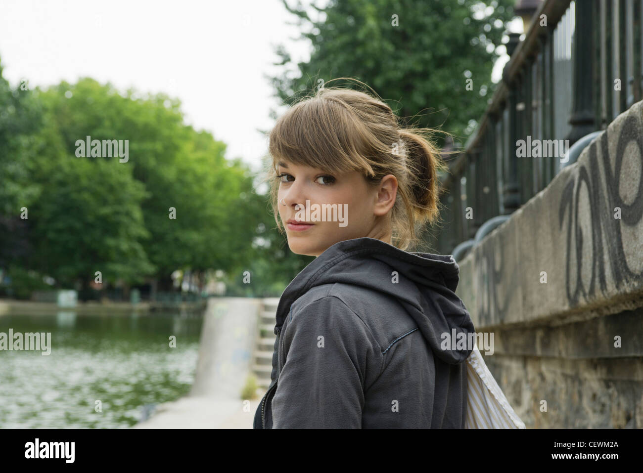 Young woman looking over shoulder, portrait Stock Photo - Alamy
