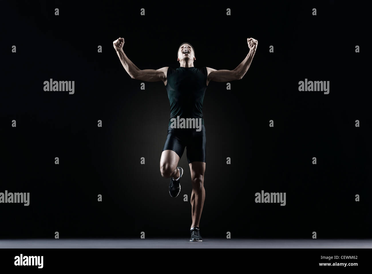 Male athlete flexing arms and shouting Stock Photo - Alamy