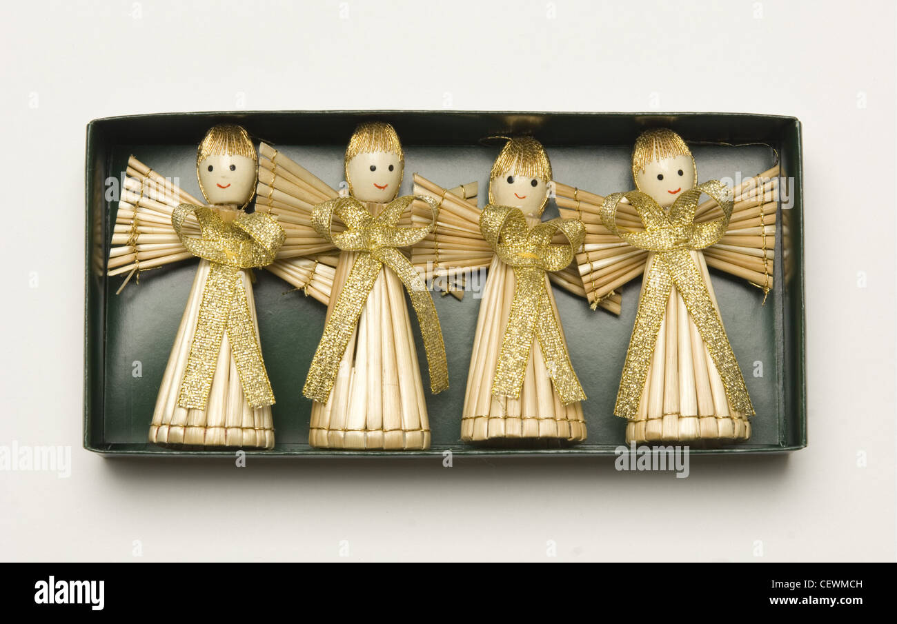 Pack of four Christmas angels made of straws lying in a green box ...