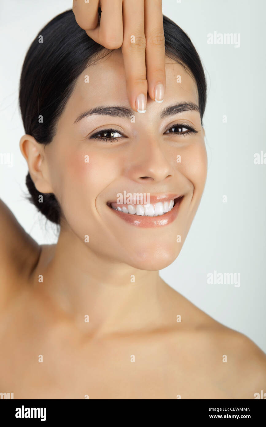 Woman placing fingers on forehead, portrait Stock Photo - Alamy