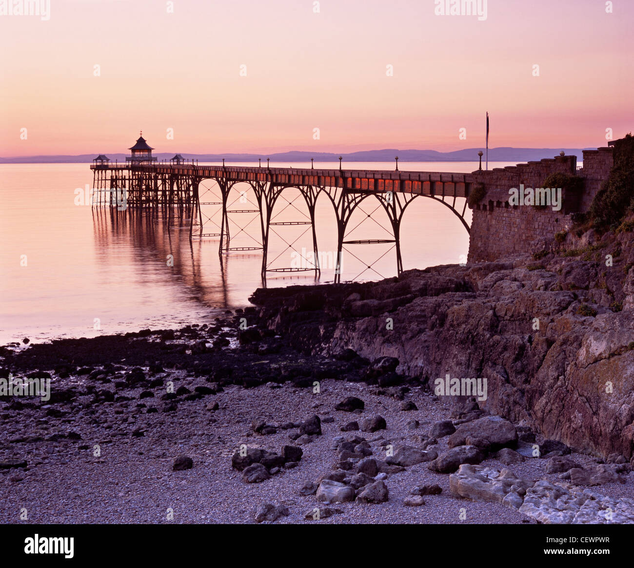 Clevedon pier and the rocky shoreline in warm light Stock Photo - Alamy