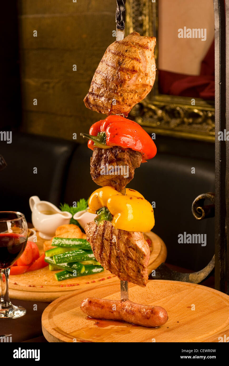 Big tasty roasted meat cuts at skewer on a decorated table Stock Photo ...