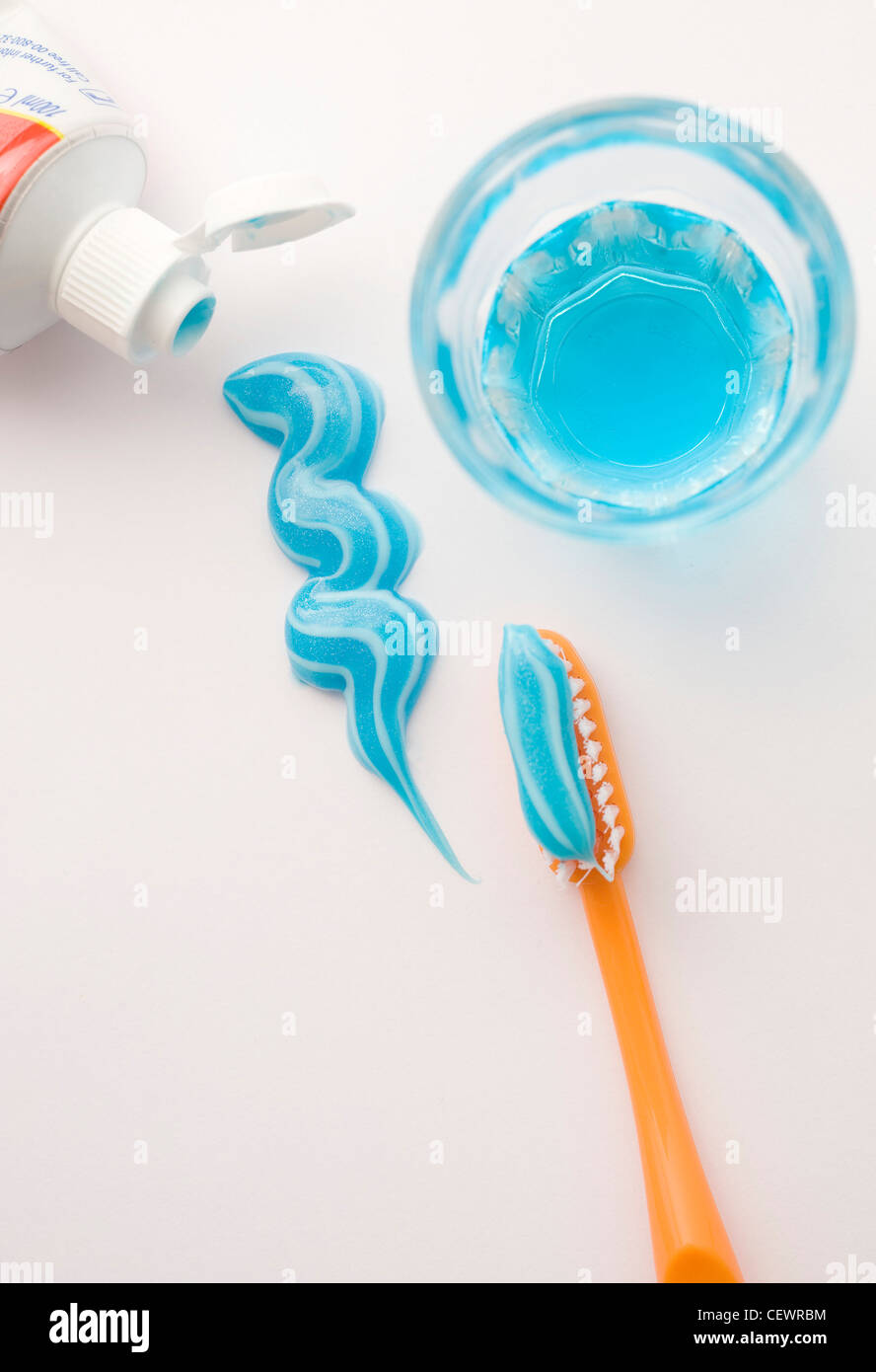 A tube of toothpaste, white and blue striped toothpaste on an orange ...
