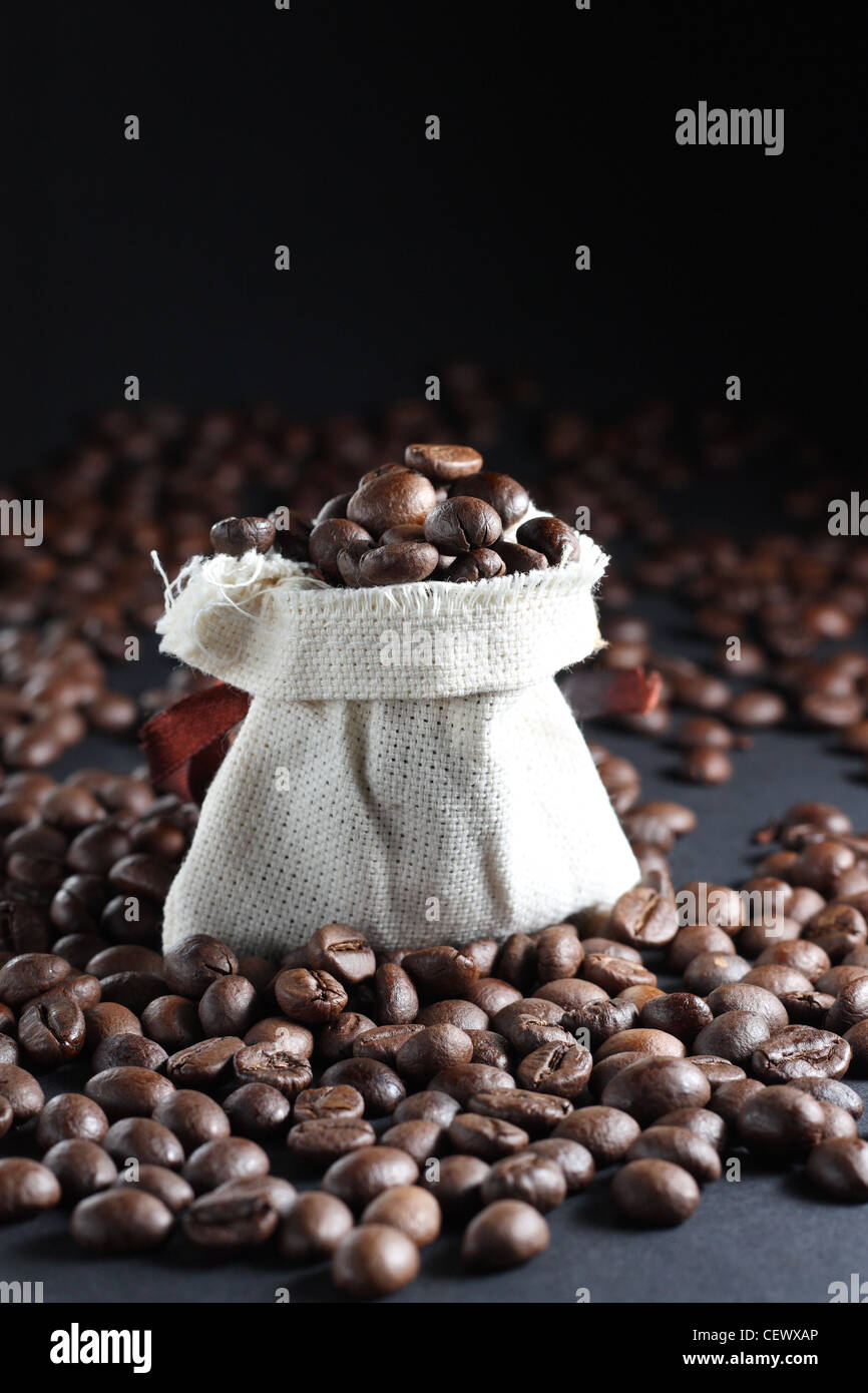 Coffee beans in a sack with a lot of beans around it Stock Photo - Alamy
