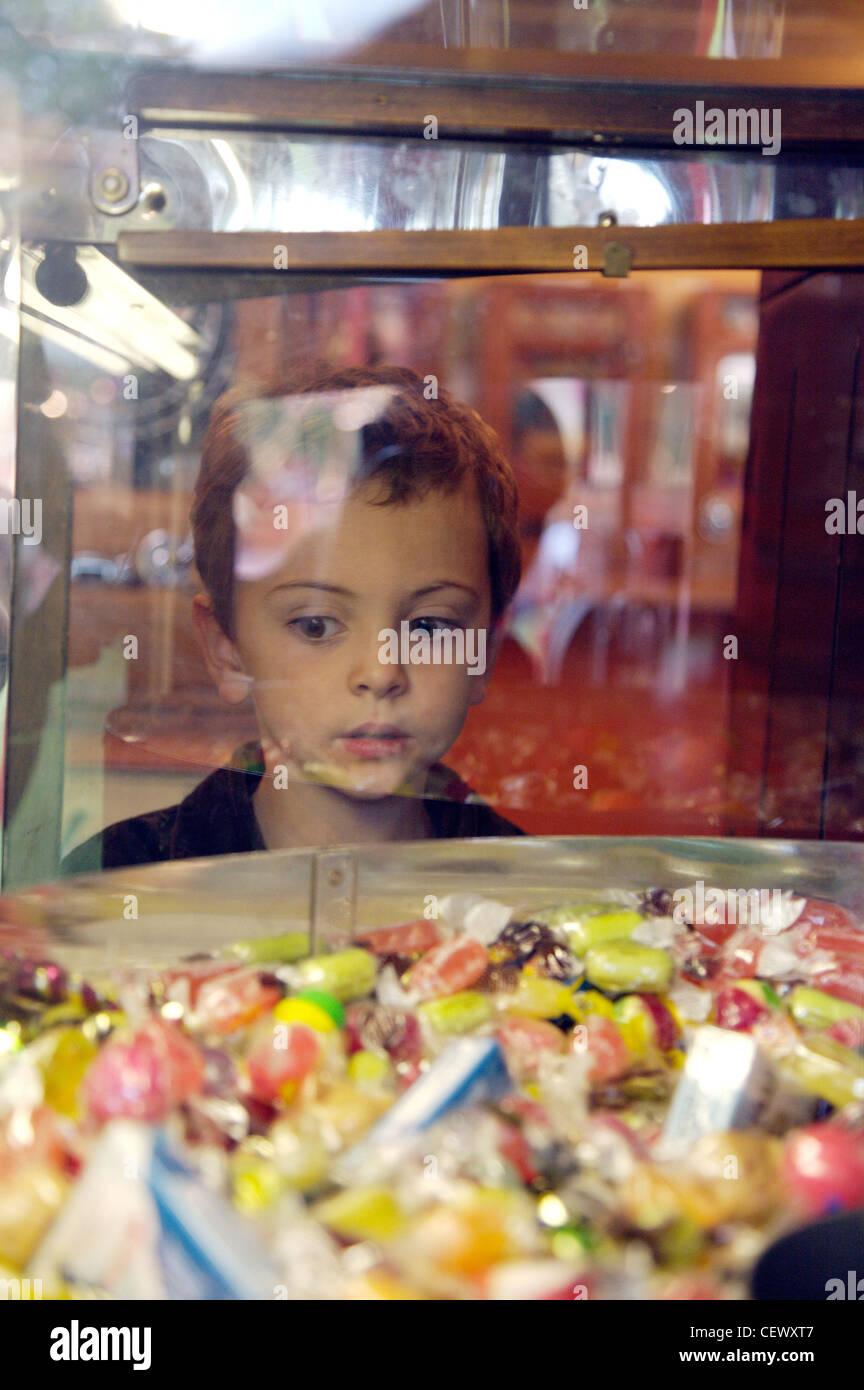 Blonde male child looking into a case full of sweets Stock Photo - Alamy
