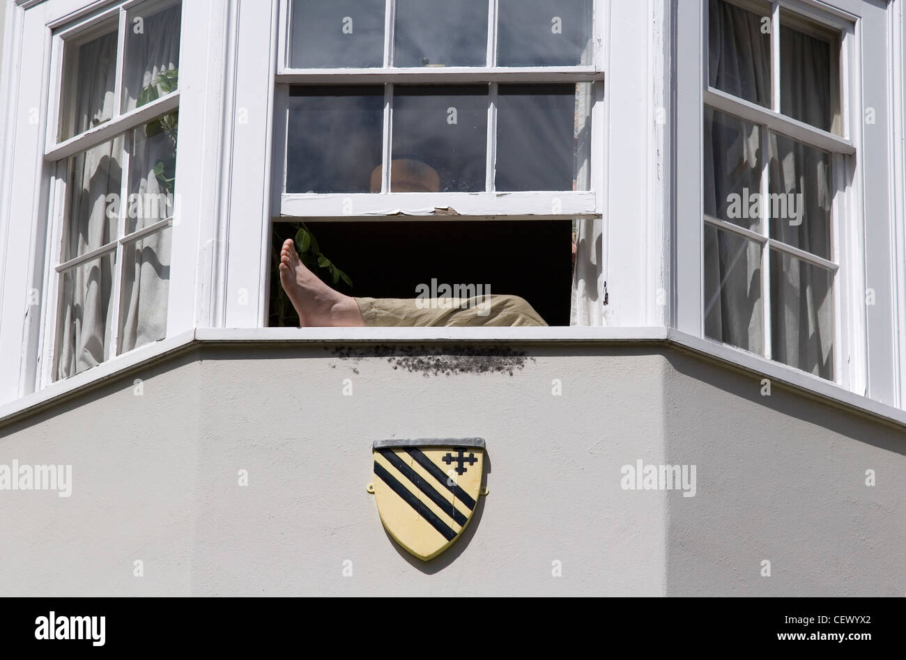 A hot, lazy day in Holywell Street, Oxford - man poking his leg out the ...