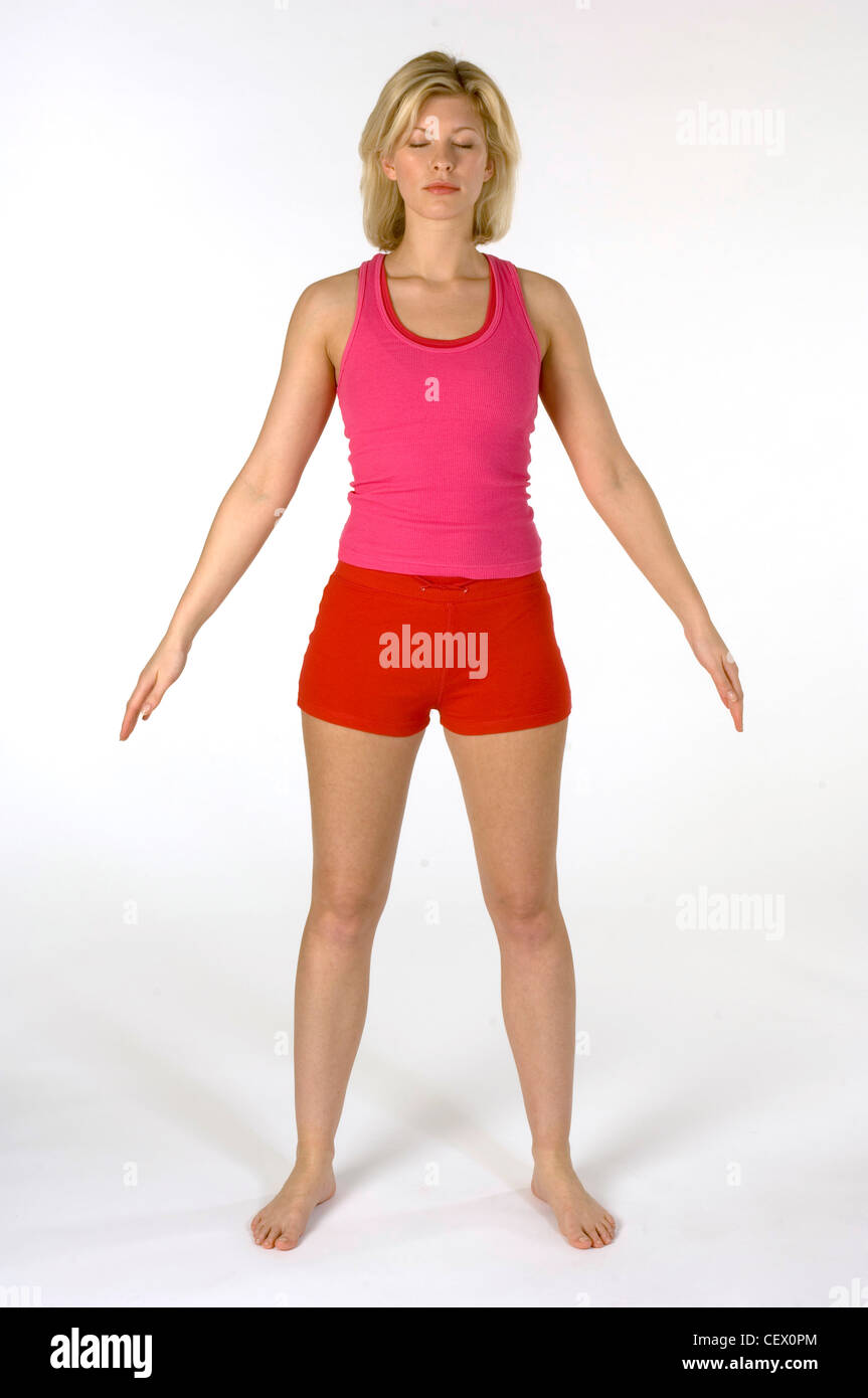 Female wearing fitness clothes standing with arms away from body, feet ...